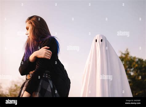 Ghost Standing Behind Scared Young Woman Outdoors During Halloween
