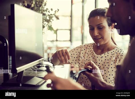 Male And Female Owners Adjusting Cable Of Computer Monitor In Cafe Stock Photo Alamy