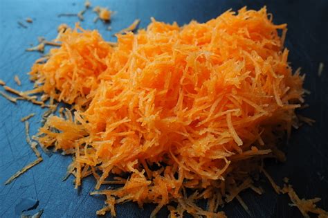 강판 당근의 질감 Daucus Carota Subsp Sativus 뿌리 채소 오렌지 색상입니다 검은 도마에 강판 당근 0명에