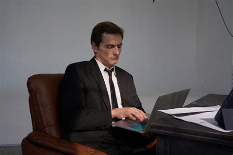 사무실에 앉아 노트북 컴퓨터로 작업하는 사업가의 비즈니스 초상화 젊은 사업가가 사무실에서 노트북으로 작업하고 있습니다 복사할 공간입니다 고품질 사진 30 34세에 대한 스톡