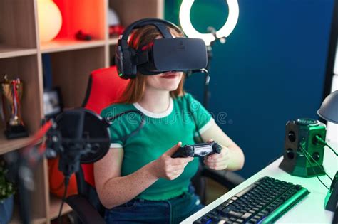 Young Redhead Woman Streamer Playing Video Game Using Virtual Reality
