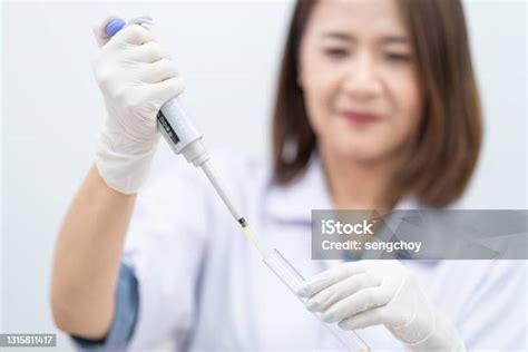 연구 연구 현대 실험실에서 과학 실험을 검토하기 위해 플라스틱 의료 튜브와 함께 일하는 젊은 여성 연구원 의사 과학자 또는