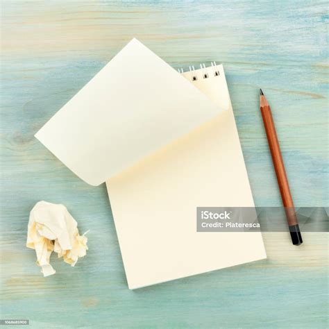 새로운 페이지를 돌고 있습니다 나선형 노트 패드의 종이 구겨진된 페이지의 빈 시트와 리드 연필로 청록 파란색 배경에 위에서 촬영