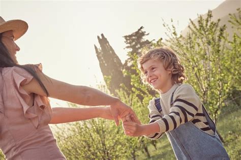 Premium Photo Mother And Son Holding Hands On Sunny Day