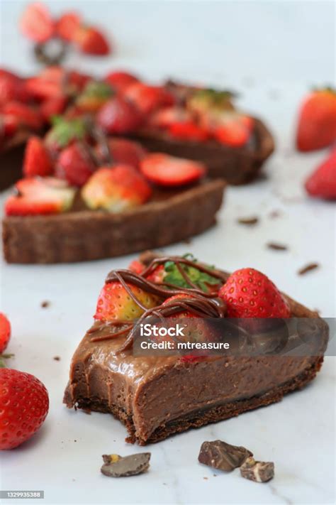 초콜릿 딸기 타르트 슬라이스 누락 물린 코코아 페이스트리 크러스트 녹은 초콜릿 칼 대리석 효과 배경으로 이슬비 전체와 반쪽 딸기를 얹은 이미지 전경에 초점을 맞추고 0명에