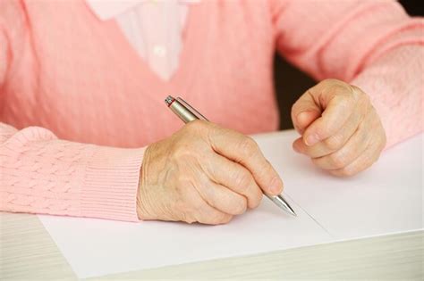 Premium Photo Hands Of Adult Woman Writing On Table On Light Background
