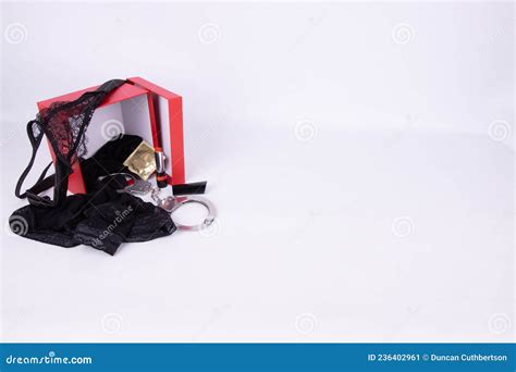 A Red Gift Box Filled With Romantic Items And Lingerie Inside Like Stockings Hand Cuffs And Red