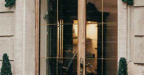 세련된 크리스마스 장식 화환 조명 유럽 도시 거리의 창문에 장식품이 있는 전나무 가지 겨울 휴가 도심의 축제 거리 장식 및