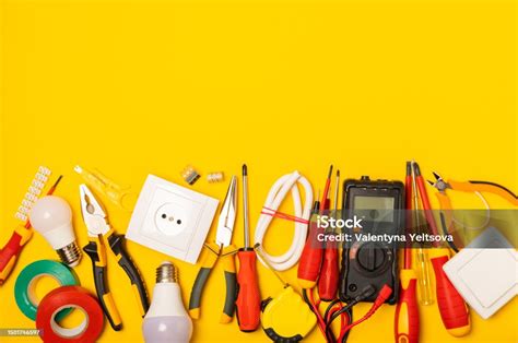 복사 공간이 있는 노란색 배경에 전기 장비 평면도 전기 공구 세트 멀티 미터 테스터 스크루 드라이버 커터 덕트 테이프 램프 줄자 및 와이어 플렛 누워 0명에 대한 스톡 사진