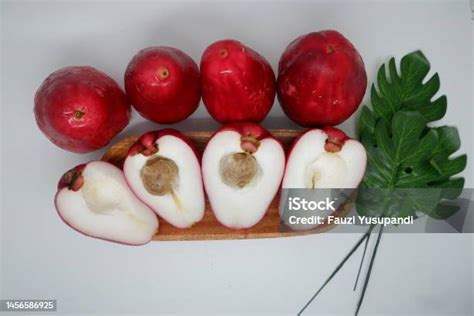 잘 익은 말레이 사과 또는 자두 Syzygium Malaccense 뒤에 4 개의 Plumrose가있는 나무 쟁반에 제공