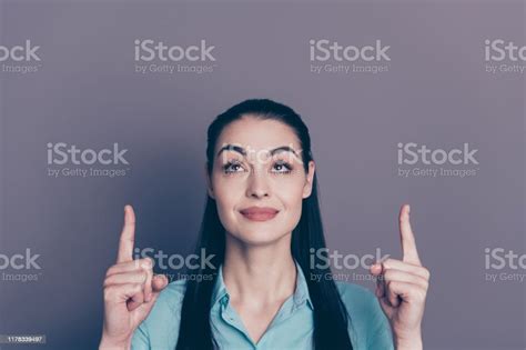 당신이 회색 색상 배경을 통해 격리 필요한 정보를 보여주기 위해 빈 공간을 가리키는 매력적인 귀여운 좋은 사무실 관리자의 사진을 닫습니다 가리키기에 대한 스톡 사진 및 기타