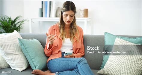 문자 메시지를 위해 집 거실 소파에 앉아 여성과 앱 통신 및 전화 아파트에 있는 진지한 사람과 연락하고 긴장을 풀고 소셜