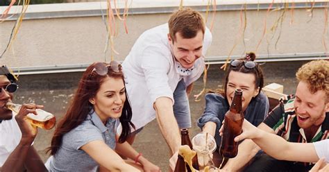 맥주와 함께 병으로 건배를합니다 캐주얼 한 옷을 입은 젊은이들이 낮에 옥상에서 함께 파티를합니다 사진 Unsplash의 우정 이미지