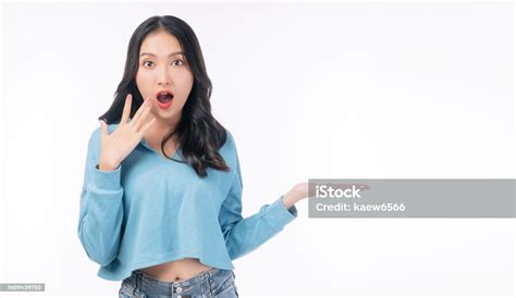 흥분한 기쁨 아시아 여자는 하얀 배경에 빈 서있는 손을 들어 올렸다 자신감 넘치는 미소 어린 소녀가 손에 복사 공간을 보여 주며 고립 된 제품을 제시합니다 광고 프리젠