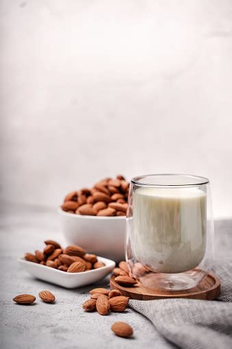 흰색 콘크리트 배경에 아몬드 씨앗이 있는 아몬드 우유 한 잔 0명에 대한 스톡 사진 및 기타 이미지 0명 갈색 건강관리와 의술 Istock