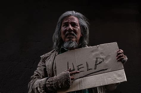 노숙자 빈곤 한 남자가 벽에 도움을 청하는 표지판을 들고 있습니다 돈을 구걸하는 수염을 가진 늙은 동정심 많은 남자 사회의 경제 문제는 희망없는 노인을 버렸다 집에 있는