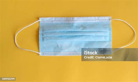 노란 배경의 박테리아로부터 보호하기 위해 입과 코를 덮는 귀 루프가있는 파란색의 일회용 의료 보호 마스크 1 개 0명에 대한 스톡 사진 및 기타 이미지 Istock