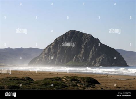 Morro Rock Seen From The Beach Sits In The Pacific Ocean Near Morro