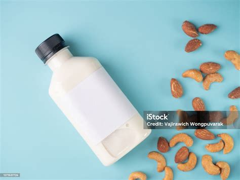 빈 로고 라벨이 있는 플라스틱 병 용기에 흰색 파스텔 컬러 드링크 스튜디오 배경에 많은 야채와 과일 스무디 주스를 혼합 캐슈 너트 아몬드 장식 0명에 대한 스톡 사진 및