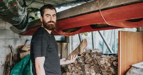 나무 더미 옆에 서 있는 남자 사진 Unsplash의 직업 이미지