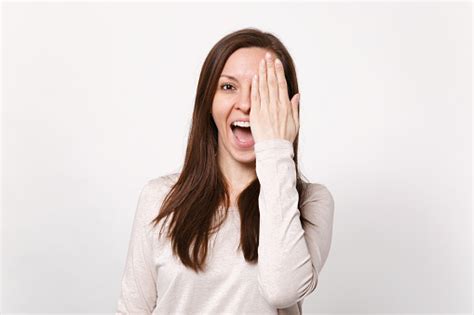 밝은 옷 입에 입을 유지 하는 쾌활 한 젊은 여자의 초상화 스튜디오에서 흰색 배경에 고립 된 손바닥으로 얼굴을 덮고 사람들은 진심으로 감정 라이프 스타일 개념입니다 복사