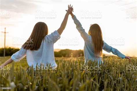 밀밭에 서 있는 두 명의 청녀 그들은 밀밭 한가운데 서 팔을 들고 손을 들고 서 있었다 2명에 대한 스톡 사진 및 기타 이미지 2명 계절 고요한 장면 Istock