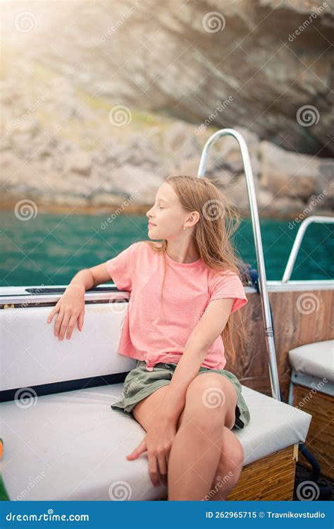Adorable Girl Sailing On Boat In Clear Open Sea On Summer Vacation