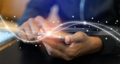 스마트 폰에서 젊은 남자 손 터치 스크린을 닫고 비즈니스 및 기술 개념에 대한 디지털 혁신에 대한 미래 지향적 인 라인을 검색하거나 작업합니다 휴대전화에 대한 스톡 사진 및