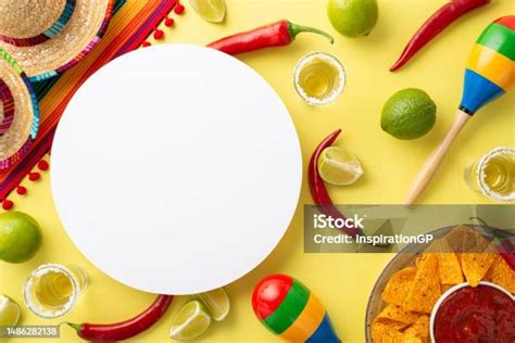 솜브레로 판초 마라카스 데킬라 샷 라임 칠리 페퍼 나초 칩 살사 소스와 같은 멕시코 테마 아이템이 빈 원이 있는 생생한 노란색 배경에 있는 플랫 레이 사진 0명에 대한 스톡