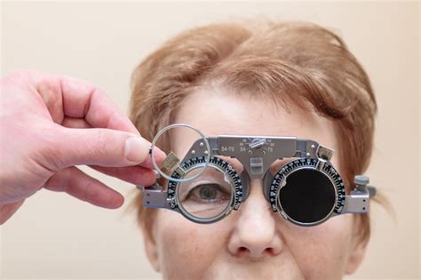 Premium Photo A Male Optometrist Checks The Eyesight Of An Adult Woman With A Trial Frame