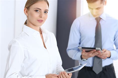 아름 다운 금발 사업가 밝은 조명에 똑바로 서 있는 동안 태블릿 Pc를 사용 하 여 비즈니스 개념입니다 개념에 대한 스톡 사진