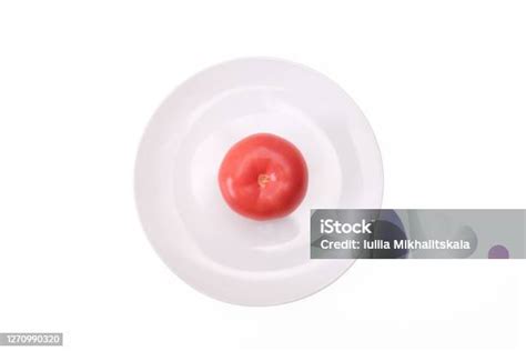 흰색 지중해 다이어트 개념에 고립 된 흰색 세라믹 접시에 하나의 빨간색 잘 익은 신선한 생 토마토 건강한 생활방식에 대한 스톡