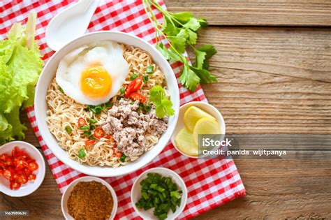 인스턴트 국수 요리 그릇으로 맛있는 먹기 삶은 계란으로 그릇 다진 돼지 고기 야채 봄 양파 레몬 라임 양상추 셀러리와 칠리 테이블 음식 국수 수프 위쪽 전망 긴급 개념에