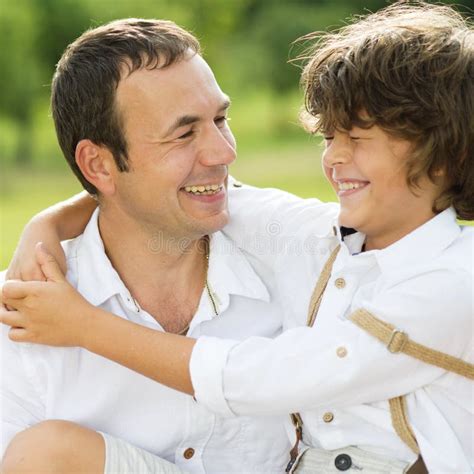 A Middle Eastern Man And His Son Sitting In A Park Stock Image Image