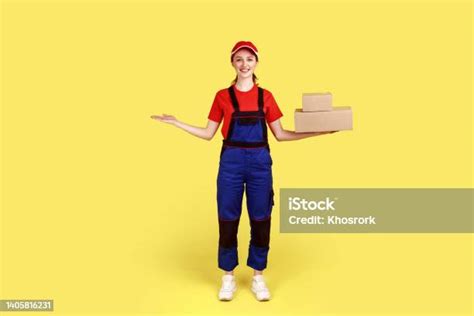 낙관적 인 배달 여성은 골판지 패키지를 들고 서서 손바닥에 복사 공간을 제시합니다 20 24세에 대한 스톡 사진 및 기타 이미지 20 24세 광고 구매 Istock