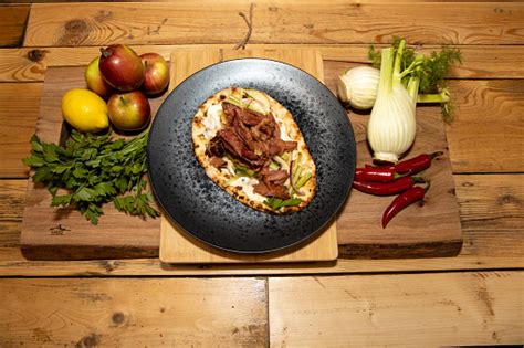 나무 부엌 테이블에 요리를 만드는 데 사용되는 재료로 둘러싸인 애플 슬로와 파쇄 햄의 맛있는 접시 건강한 생활방식에 대한 스톡