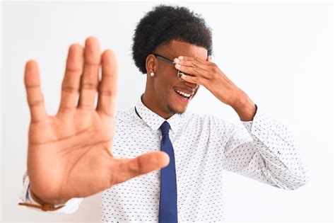 고립된 흰색 배경 위에 넥타이와 안경을 쓰고 손을 잡고 슬프고 두려움의 표정으로 제스처를 멈추고 있는 젊은 아프리카계 미국인 사업가 부끄럽고 부정적인 개념 남자에 대한 스톡