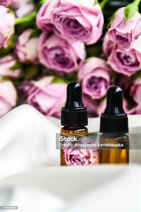 로즈 오일 스파와 아로마테라피 로즈 플라워 에센셜 오일 병 새틴 샴페인 컬러 원단에 파이펫을 장착 장미 에센셜 오일과 신선한 꽃병 건강관리와 의술에 대한 스톡 사진 및 기타