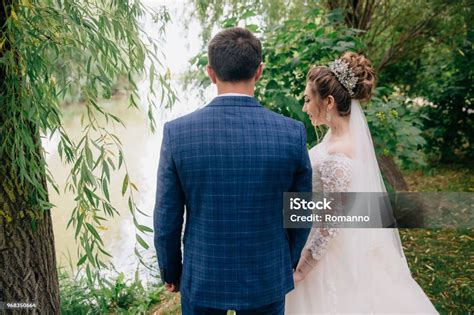 그들의 결혼 날에 신부 및 신랑의 후면 보기 아름 다운 녹색 공원에 산책 하기로 결정 했습니다 신혼 부부 자연과 서로 친교를 즐길 수 2명에 대한 스톡 사진 및 기타 이미지