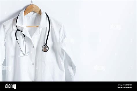 Doctors White Coat With Stethoscope On Hanger Over White Background