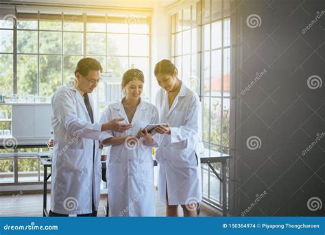Group Of Asian Scientist Using Tablet Computer And Analyzing Data