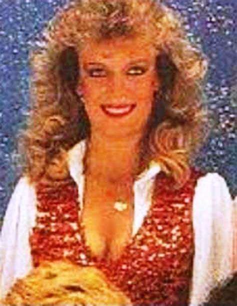 A Woman With Blonde Hair Wearing A Red And White Shirt Holding A Yellow Teddy Bear