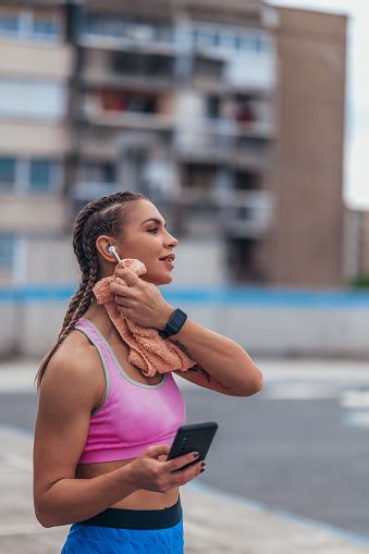 외부 훈련 및 피트니스 운동 후 스마트 폰을 사용하여 스포츠웨어에 매력적인 여성 Brand Name Smart Phone에 대한 스톡 사진 및 기타 이미지 Brand