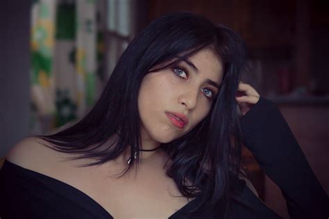 초점을 맞추지 않은 배경이있는 빈티지 안락 의자에 앉아있는 녹색 눈을 가진 아름다운 모델의 초상화 관능에 대한 스톡 사진 및