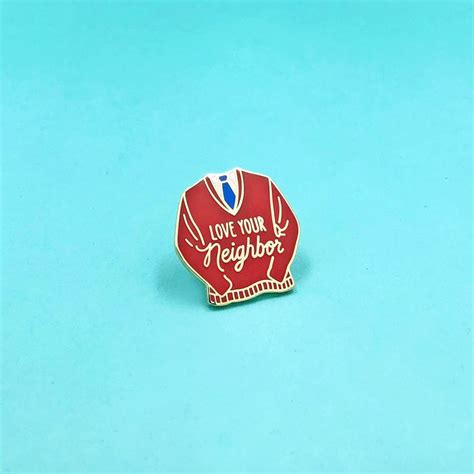 A Red Elephant Pin With The Words Love Your Neighbor Written On Its Back