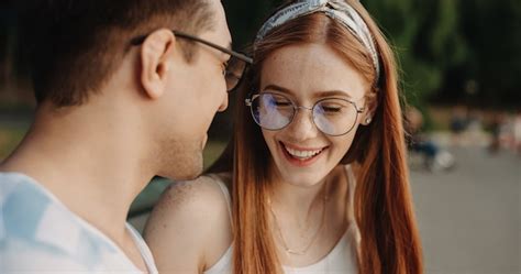 Cerrar el retrato de una joven pareja encantadora donde la mujer está mirando hacia abajo riendo