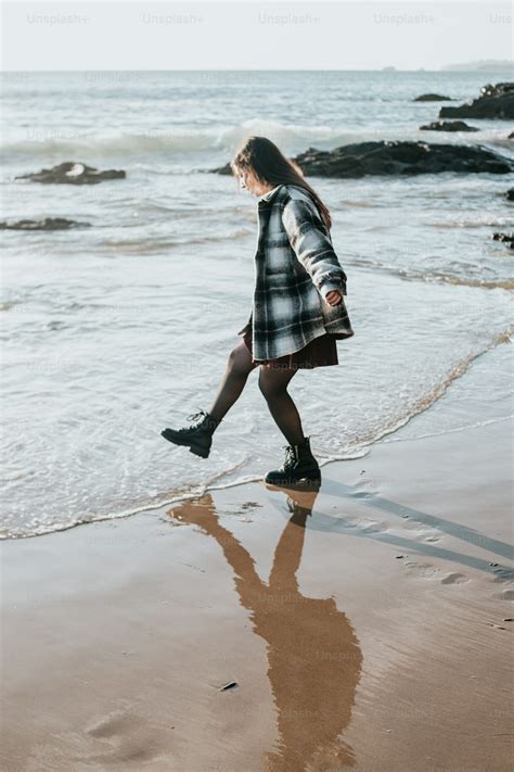 바다 옆 해변을 따라 걷는 여자 사진 Unsplash의 여성 이미지