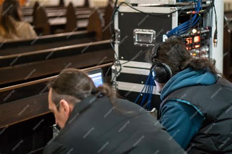 Premium Photo A Sound Engineer With Headphones Sits In Front Of A Laptop While Recording Or