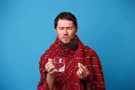 Premium Photo A Wrapped In A Blanket Sick Man With Tablet And Mug