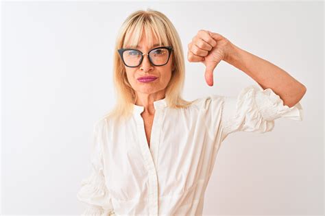 셔츠와 안경을 쓰고 화가 난 얼굴로 고립된 흰색 배경 위에 서 있는 중년 사업가 엄지손가락으로 싫어하는 것을 보여주는 부정적인 표지판 거부 개념 거절에 대한 스톡 사진 및